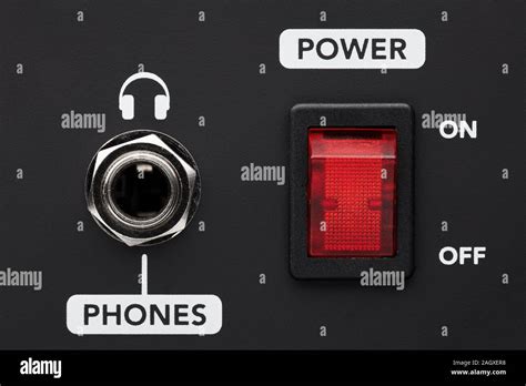 Power On And Off Electrical Switch Button And Headphone Input Jack On A Black Amplifier