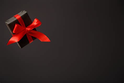 검은 색 배경에 공기에 떠있는 빨간 활과 아름다운 비행 검은 선물 상자 블랙 프라이데이 세일 크리스마스 세일 할인 컨셉 발렌타인