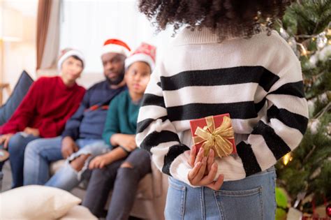 행복한 아프리카 가족은 집에서 거실에서 크리스마스 날에 아빠와 엄마와 함께 깜짝 선물 상자를 숨기고 축하 크리스마스 새해 부모와