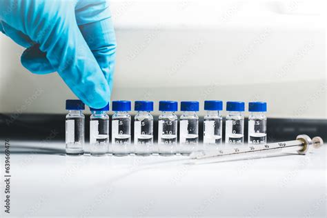 Hand Of The Scientist Pick Up The Vial Of Sample Solution To Analyze By