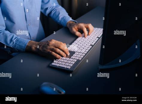 Top View Of Hands Of Unrecognizable Man Using Computer Typing On Wireless Keyboard At Dark Room