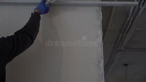 Leveling The Plaster Layer On The Wall With A Metal Spatula The