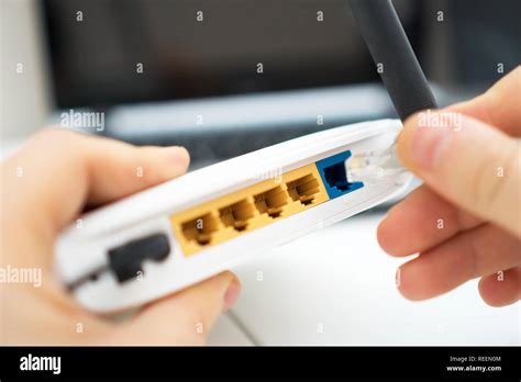 Man Plugging Internet Cable Into Wifi Router Stock Photo Alamy