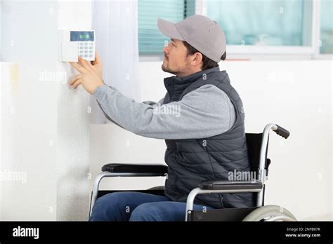 Male Electrician Installing Security System Door Sensor On Wall Stock