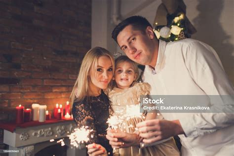 행복한 가족 크리스마스 트리와 촛불이있는 벽난로의 배경에 스파클러를 들고 어머니 아버지와 딸 부모에 대한 스톡 사진 및 기타 이미지 Istock