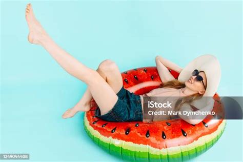 수영복과 여름 모자를 쓰고 풍선 반지에 앉아 파란색 배경에 고립 된 행복한 아름다운 소녀 공기 주입에 대한 스톡 사진 및 기타 이미지 공기 주입 모자 모자류 사람들