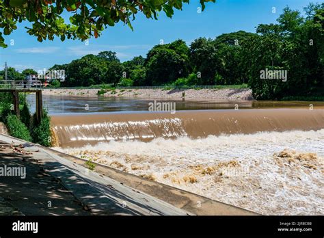 View Of Muddy Water Streams Rushing Rapidly On The River Flowing Over A Weir Falling Down