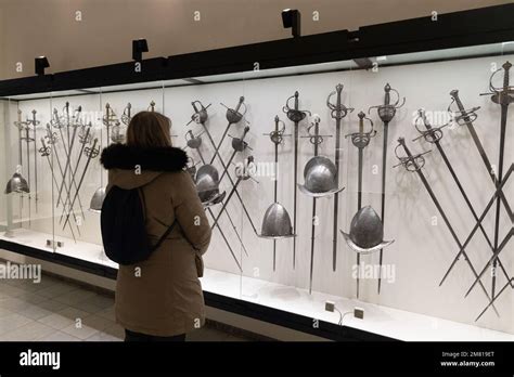 A Visitor Looking At Weapons Of Medieval Warfare Including Swords And