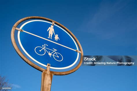 푸른 하늘을 배경으로 녹슨 기둥에 보행자와 자전거 타는 사람을 위한 파란색 원형 표지판 0명에 대한 스톡 사진 및 기타 이미지