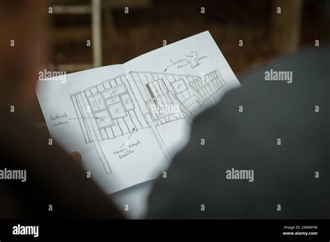 Two People Looking At The Plan Drawings For A Treehouse Stock Photo Alamy