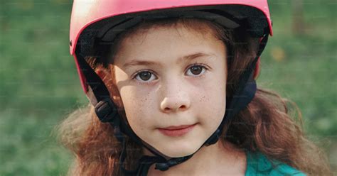 여름날 공원에서 분홍색 헬멧을 쓴 사랑스럽고 귀여운 백인 소녀의 클로즈업 초상화 계절에 따라 야외 어린이 활동 스포츠 건강한 어린 시절의 생활 방식 소녀의 힘 웹