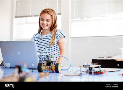 Female Student Building And Programing Robot Vehicle In After School Computer Coding Class Stock