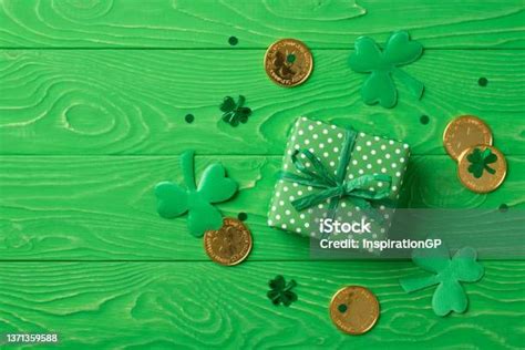 분리 된 질감녹색 나무 책상 배경에 물방울 무늬 클로버 모양의 색종이와 금화와 세인트 패트릭의 날 장식 Shamrocks 녹색 선물 상자의 상단 보기 사진 3월에 대한 스톡