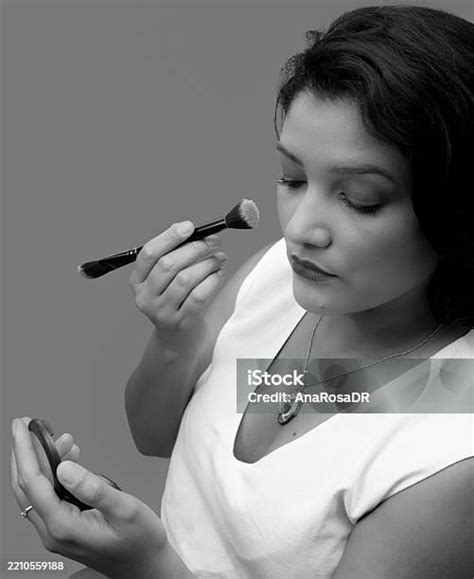 여자는 흑백 이미지로 화장을 하고 컴팩트 거울과 브러시를 들고 표정에 집중했습니다 거울에 대한 스톡 사진 및 기타 이미지 거울 그레이 스케일 메이크업 화장품 Istock