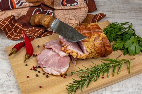 나무 도마에 육즙이 많은 돼지 고기 햄 조각 칼 붉은 고추 멀티 컬러 피망 파슬리 딜 및 바질을 얇게 썬다 맛있는 돼지 고기 제품의 개념 0명에 대한 스톡 사진 및 기타