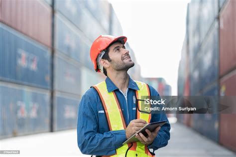 남성 작업자는 컨테이너 화물 현장에서 디지털 태블릿으로 작업하고 컨테이너 상자를 적재하고 상품을 적재하고 컨테이너를 점검하고