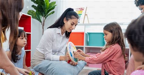 학교에서 아이들에게 예술을 가르치는 백인 아름다운 젊은 여성 교사 매력적인 강사 마스터 여성은 교실에서 학생 유치원 유치원과 함께 그림과 그림을 설명하고 교육합니다 사진
