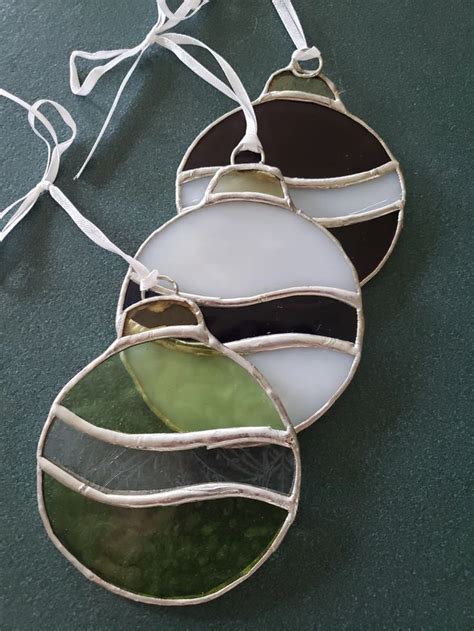 Three Stained Glass Ornaments Hanging From A String