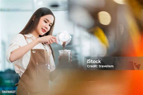 행복 쾌활한 아시아 여성 여성 유니폼 중소 기업 커피숍 주인 커피숍에서 일하는 우유를 붓는 카페에서 커피 머신으로 커피를 만드는 중국 여성 바리스타 만들기에 대한 스톡 사진