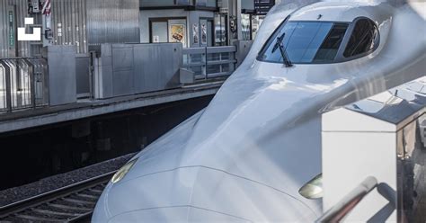A White Bullet Train Parked At A Train Station Photo Free Train Image