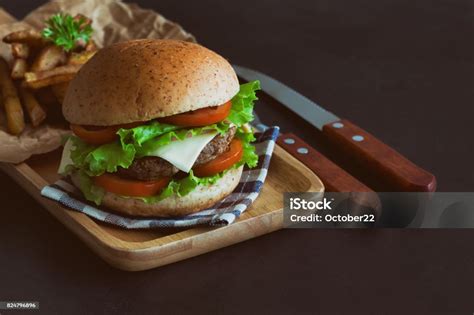 수 제 햄버거와 감자 튀김 격자 무늬 냅킨에 맛 있는 샌드위치 햄버거 고기 또는 돼지고기 햄 치즈와 신선한 야채 햄버거 나 샌드위치 브런치 나 점심에 대 한 인기 있는