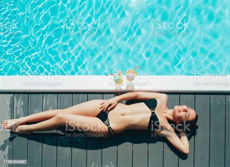 아름다운 여자는 물 근처 수영장에서 일광욕 물 수영장 근처에 누워 있는 최고 전망 무두질 한 여자 수영장 스포츠 경기장에 대한 스톡 사진 및 기타 이미지 Istock