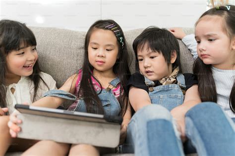 디지털 태블릿에서 영화 영화 만화를 함께 보는 어린 아이들 아이들은 집에서 친구들과 태블릿을 가지고 놀고 있습니다 사진
