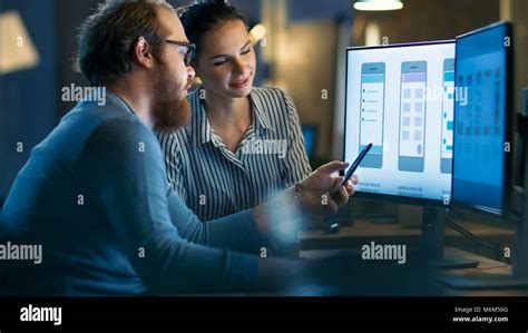 Handsome Male And Beautiful Female Mobile Application Designers Test And Discuss New App