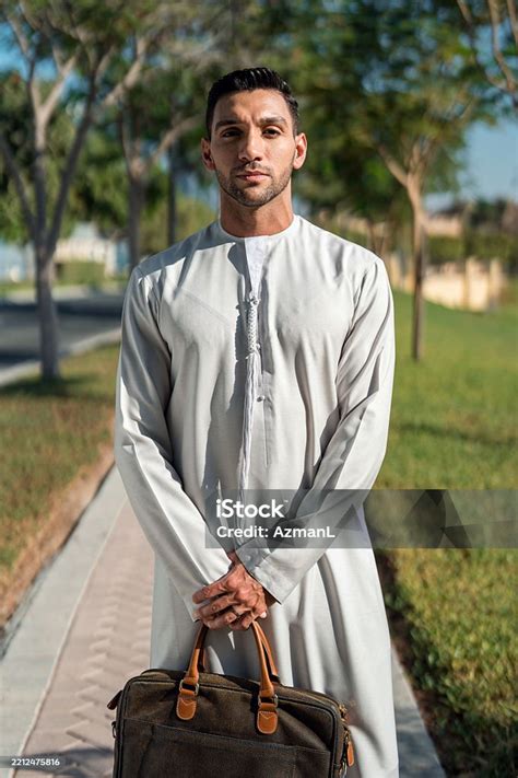 화창한 두바이 아침에 서류 가방을 들고 전통 의상을 입은 중간 성인 히스패닉 사업가 30 34세에 대한 스톡 사진 및 기타 이미지 30 34세 가방 결심 Istock