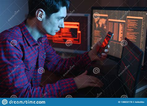 Hacker Holding The Phone In His Hands Trying To Hack The Mobile Device Cloud And Steal Data In