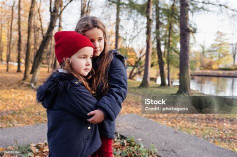 가 공원에 포옹 두 행복 한 아이 들 두 아름 다운 백인 여자의 야외 귀여운 최신 유행 옷을 입고 맑은 라이프 스타일 패션 초상화를 닫습니다 리틀 시스터즈 웃 고 인생을