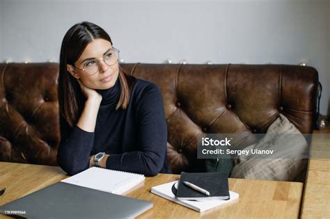 테이블에 앉아 노트북에 메모를 하는 젊은 비즈니스 여성 테이블에는 노트북 스마트폰 및 커피 한 잔이 있습니다 블로거 검사 보기에 대한 스톡 사진 및 기타 이미지 Istock