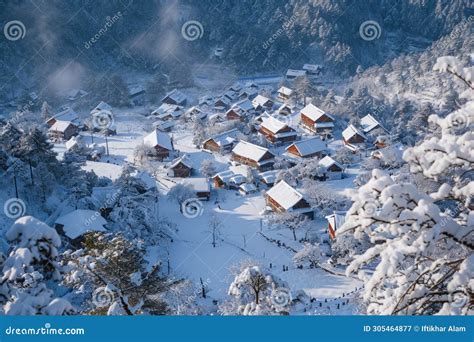 A Winter Scene Of A Mountain Village Covered In Snow Nestled Among A