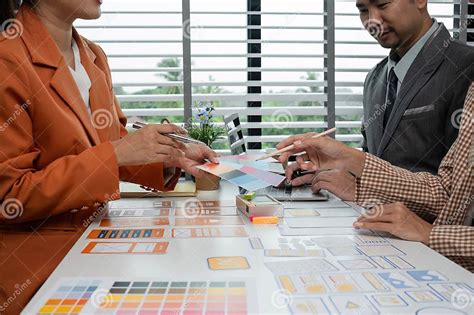 Creative Team Collaborating On Ux Ui Design Concepts With Color Swatches And Wireframes In