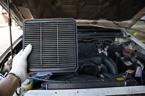 엔진 성능을 유지하기 위한 수동 자동차 공기 필터 교체 공기 필터가 막혔습니다 엔진실에서 불완전연소 여과에 대한 스톡 사진 및