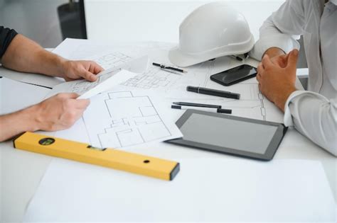 Premium Photo Engineers Are Helping To Design Work On Blueprints And Collaborate On Structural