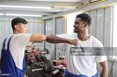 행복한 다민족 기술 정비공이 팔꿈치를 부딪치며 인사하고 차고에서 성공적인 거래를 함께 축하합니다 유지 보수 자동차 및 검사 차량 부품 개념 20 24세에 대한 스톡 사진 및