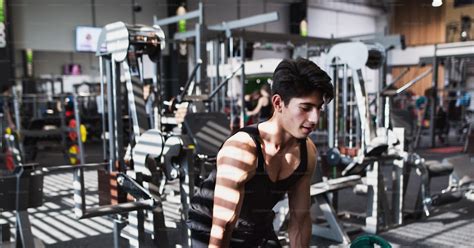 체육관에서 운동하는 젊은 잘 생긴 남자 바벨 바를 들어 올리고 근육을 구부립니다 사진 Unsplash의 보디 이미지