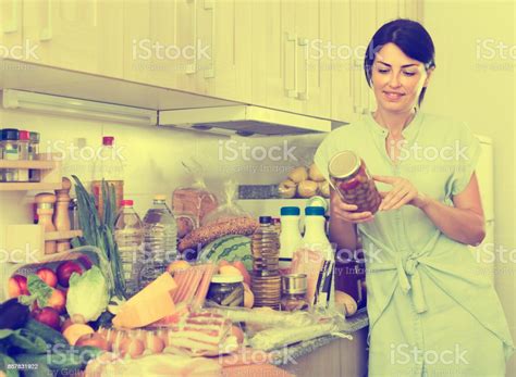집에서 새로운 레시피를 요리 하기 전에 보존을 확인 하는 쾌활 한 여자의 초상화 가득 찬에 대한 스톡 사진 및 기타 이미지 가득 찬 가방 가정 생활 Istock
