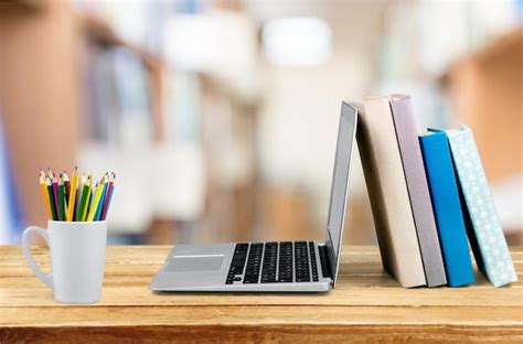 Premium Photo Stack Of Books With Laptop On Wooden Table