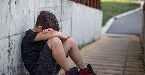 학교에 혼자 앉아 슬픈 어린 소년은 얼굴을 숨 깁니다 격리와 괴롭힘 개념 아이 슬프고 불행한 아이는 울고 화나고 아프다고 느낀다 사진 Unsplash의 슬픔 이미지