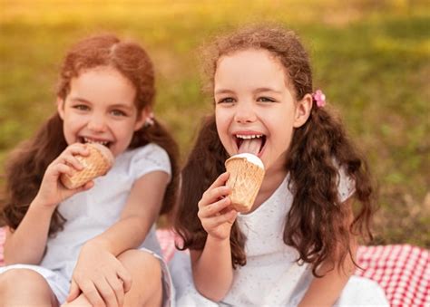 Niñas Gemelas Felices Comiendo Helados En El Parque Foto Premium
