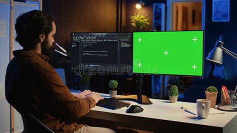 Programmer Typing Complex Code On Green Screen Computer In Neon Lit