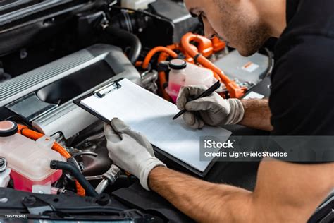 자동차 엔진실을 검사하는 동안 클립 보드에 정비사 쓰기의 자른보기 검사 보기에 대한 스톡 사진 및 기타 이미지 검사 보기