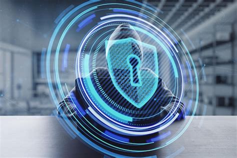 Premium Photo Hacker At Desktop Using Laptop With Glowing Shield Hologram On Blurry Office
