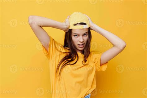 Optimista Joven Mujer Posando En Un Amarillo Camiseta Y Gorra Amarillo Antecedentes 25701416