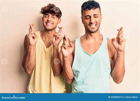 Young Gay Couple Wearing Casual Clothes Gesturing Finger Crossed
