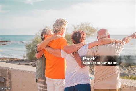 해변에서 노인의 그룹 함께 이야기하고 재미를 우정이나 배경에 바다 또는 바다와의 관계에서 행복하고 성숙한 Paople 4 명에