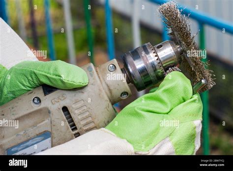 Man Inserts A Metal Brush Into An Electric Drill Stock Photo Alamy