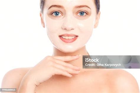 얼굴에 흰색 마스크에 갈색 머리 완벽한 피부를 가진 여자의 아름다운 사진 어린 소녀는 자신을 돌봅니다 흰색 배경에 스튜디오 사진입니다 가꿔주기에 대한 스톡 사진 및 기타